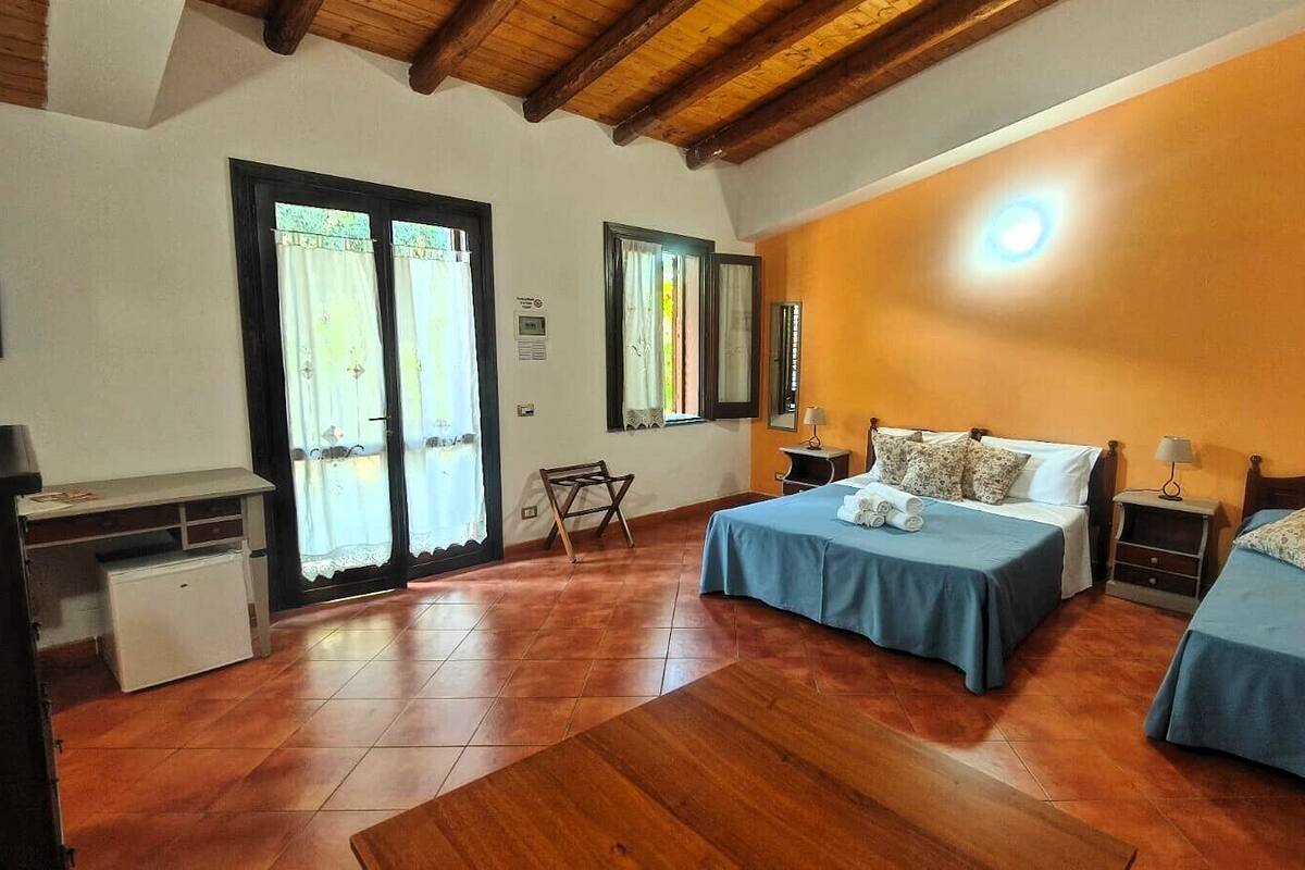 Quarto com uma cama, uma escrivaninha e uma cadeira.