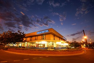 Um hotel moderno com telhado plano e uma placa com a inscrição "ISA HOTEL".