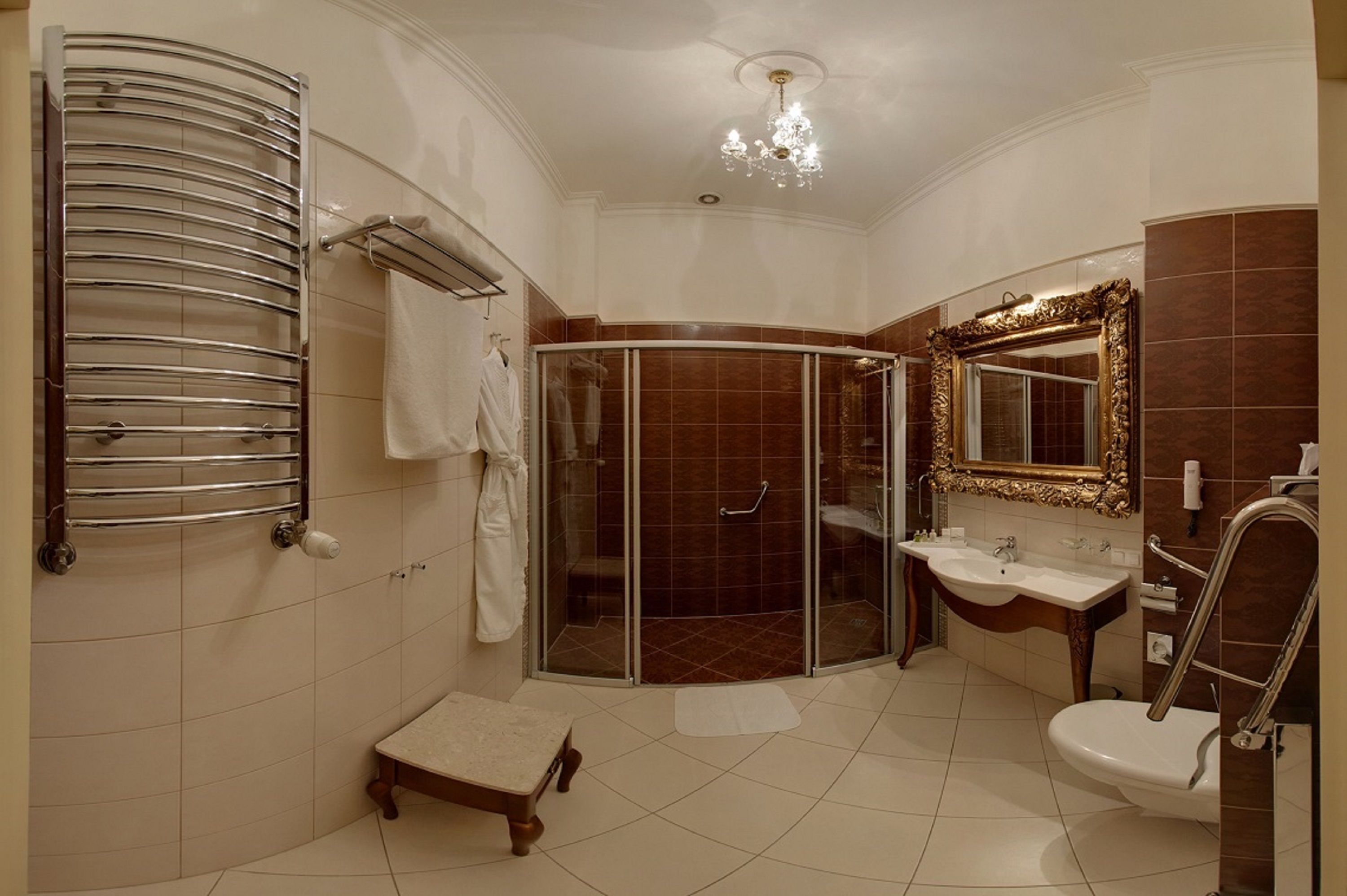 Casa de banho com cabine de duche em vidro, toucador com espelho e sanita.