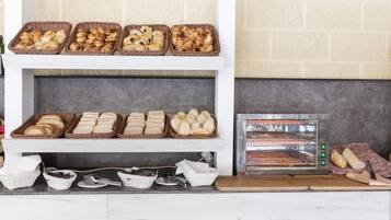 Vitrine de padaria com diversos pães e doces dispostos em prateleiras e um forno industrial.