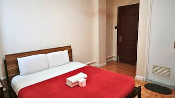 Quarto de hotel com uma cama, um guarda-roupa e uma porta.