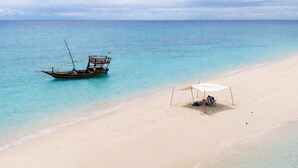 Uma praia com um barco e uma tenda.