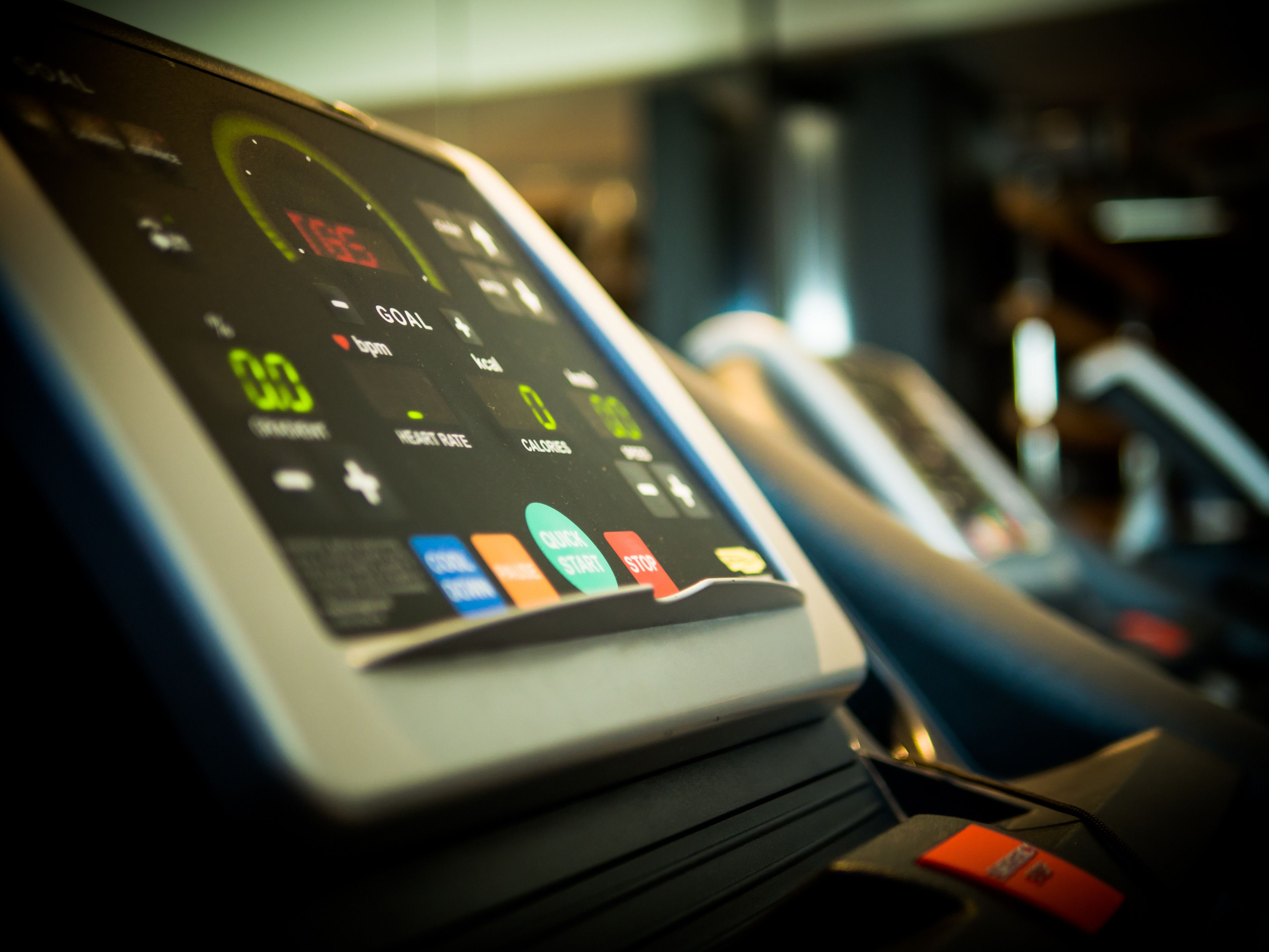 Equipamento de ginástica com visor digital exibindo informações como frequência cardíaca e calorias gastas.