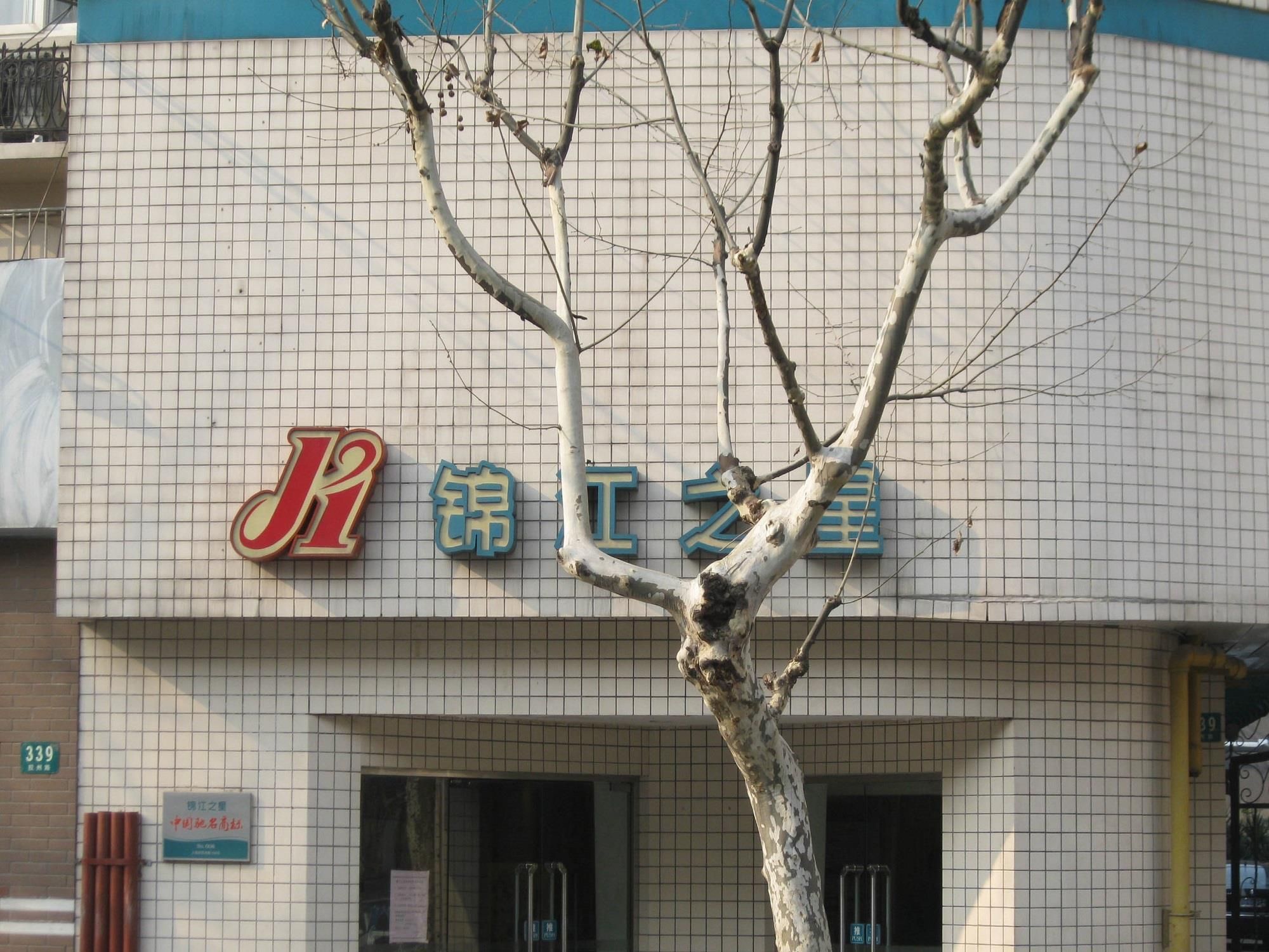 Um edifício com fachada em azulejos e uma placa com caracteres chineses.