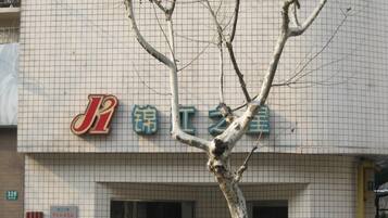 Um edifício com fachada em azulejos e uma placa com caracteres chineses.
