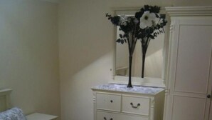 Um quarto com uma cama, cômoda e espelho.