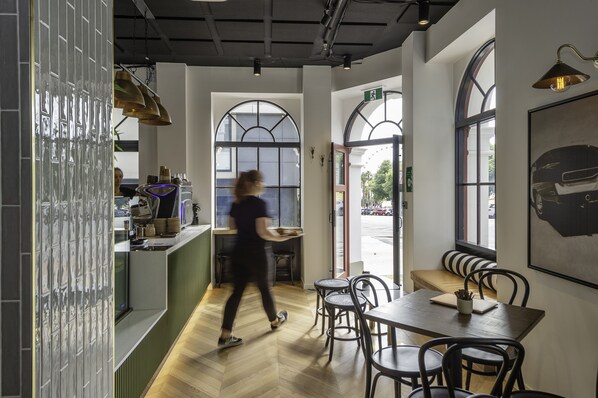 Um interior moderno com área de bar, assentos e janelas amplas.