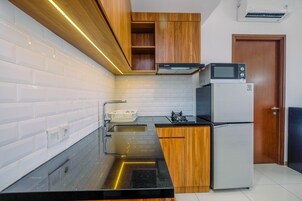 Uma cozinha moderna com armários de madeira, uma pia de aço inoxidável e micro-ondas embutido.