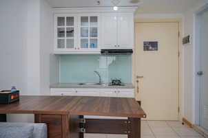 Um frigorífico, uma placa de cozinha, utensílios de cozinha