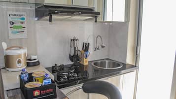 Um frigorífico, uma placa de cozinha, utensílios de cozinha