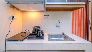 Uma cozinha compacta com design moderno, que inclui forno embutido, pia e cafeteira.