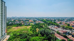 Um edifício alto com vista para uma área residencial com casas e vegetação.