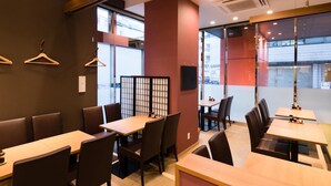Um restaurante moderno com cabines e mesas, janelas amplas e vista para a cidade.