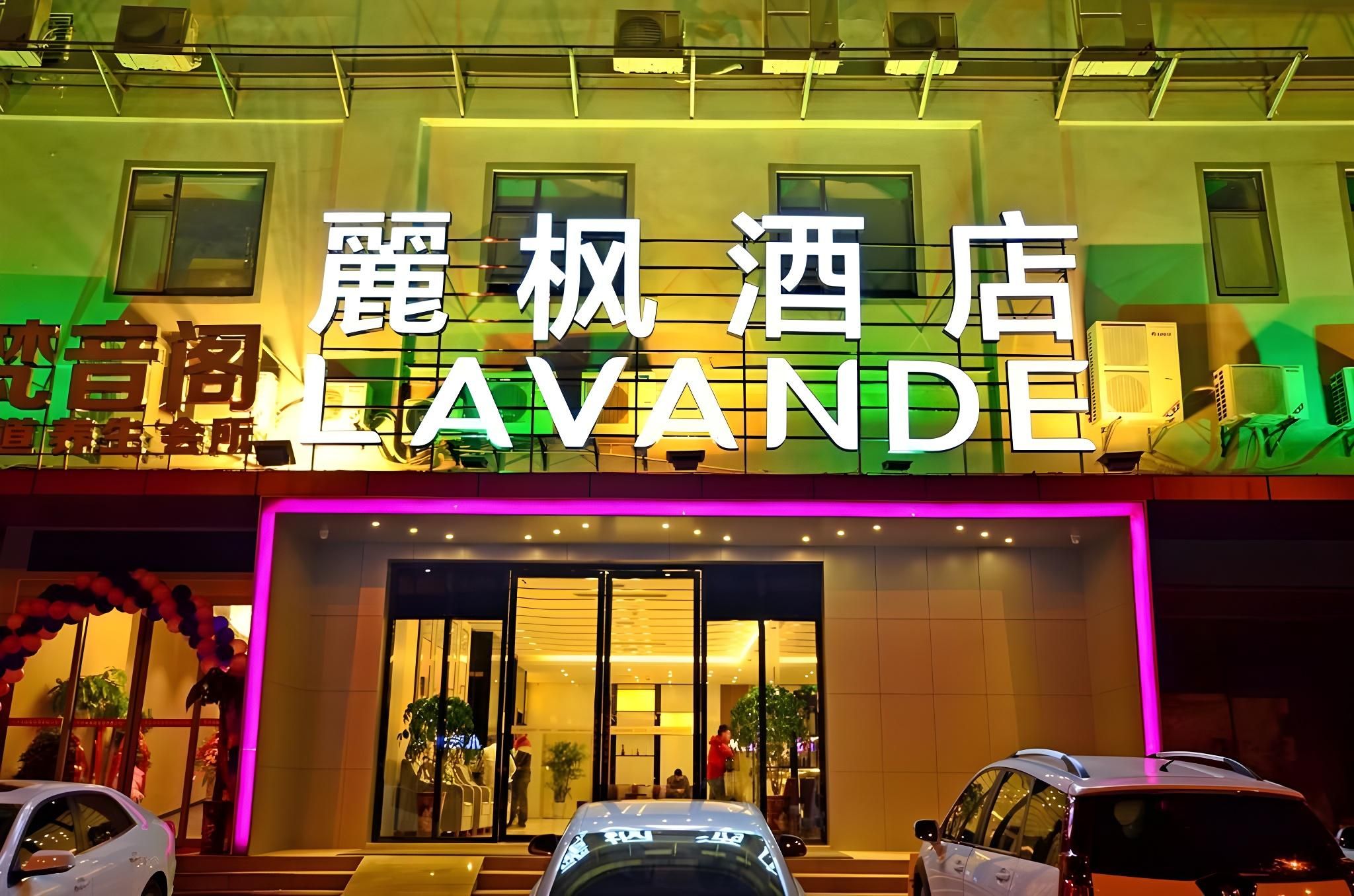 Hotel com placa de destaque com a palavra 'LAVANDE' e fachada moderna com janelas grandes e um letreiro de neon.