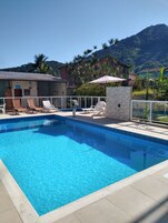 Piscina externa, guarda-sóis, espreguiçadeiras