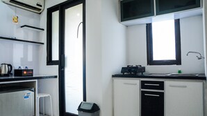 Cozinha compacta com micro-ondas, cafeteira e pia.