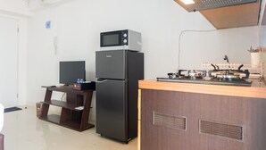 Uma cozinha compacta com geladeira, micro-ondas e fogão.