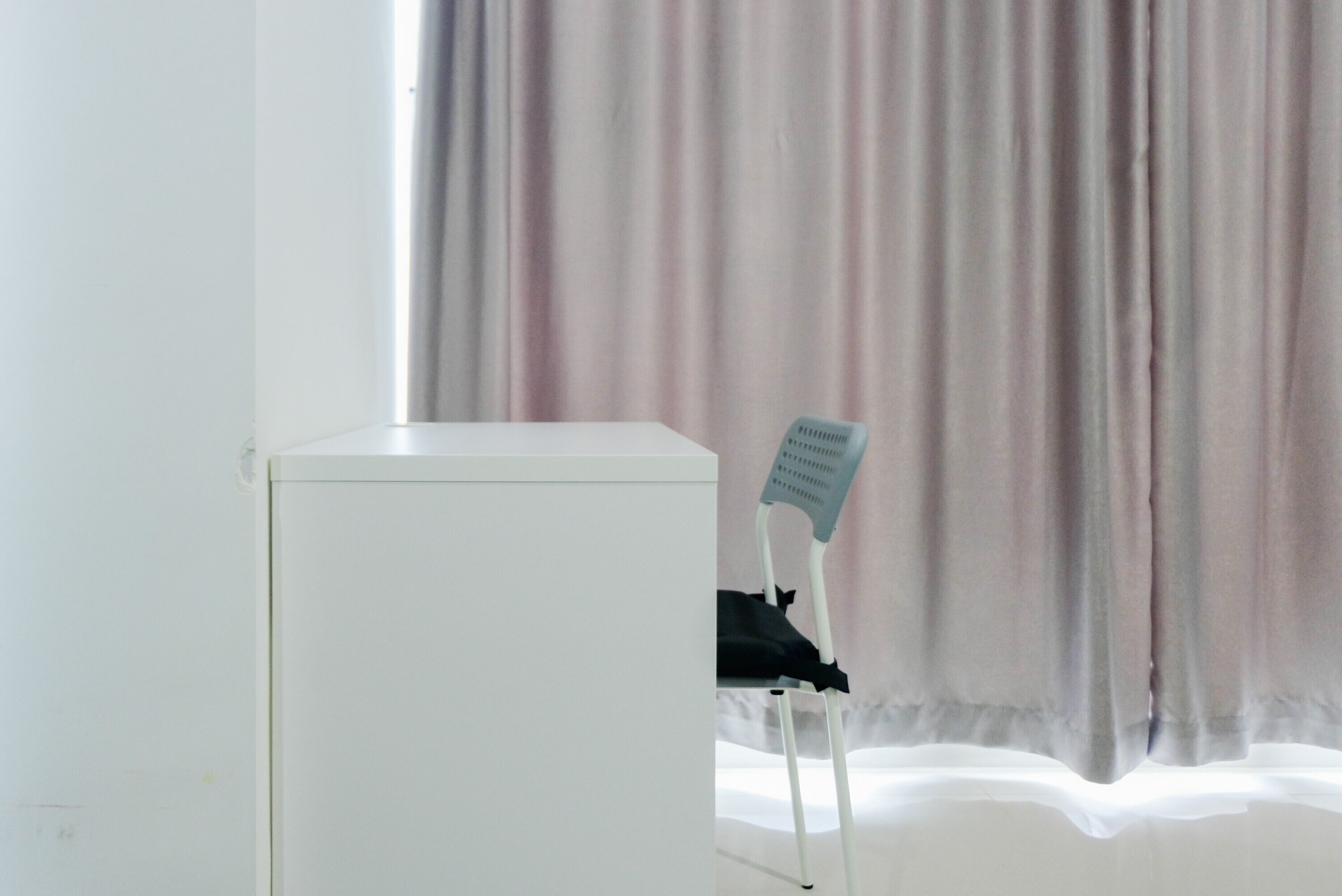 Quarto com um armário branco e uma cadeira com uma placa.