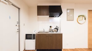 Uma cozinha compacta com micro-ondas, fogão e pia.