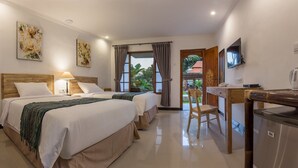 Quarto de hotel com duas camas, uma escrivaninha, máquina de café e televisão.
