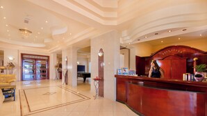 Um saguão de hotel com uma mesa de recepção, mesa de bilhar e mesa de sinuca.