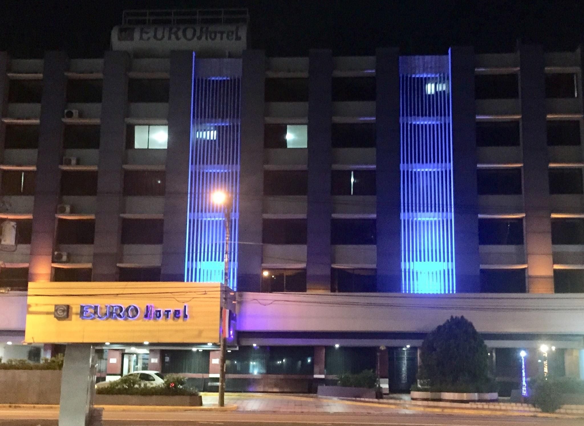 Um edifício de vários andares com uma placa indicando 'EURO Hotel'.