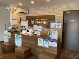 Uma receção de hotel com uma placa a indicar "HOTEL PLAISIR NAMIE".