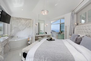 Quarto moderno com uma cama grande, uma banheira e uma toucador.