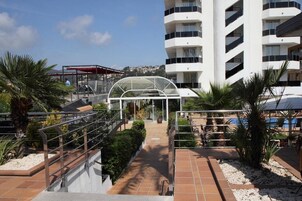 Um hotel moderno com um átrio central, área de estar ao ar livre e piscina.