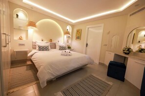 Quarto moderno com uma cama grande, mesas de cabeceira, cômoda e espelho.