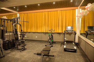 Uma academia com equipamentos de ginástica, esteira e bicicleta ergométrica.