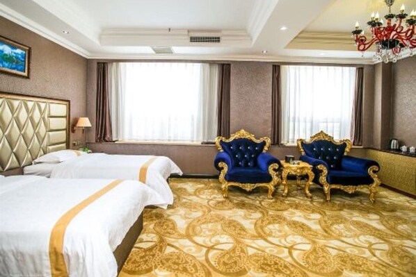 Quarto de hotel com duas camas, um candelabro e um tapete estampado.