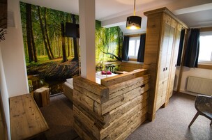 Um quarto com design rústico de cabana, um grande mural com tema de floresta na parede, um banco de madeira e uma janela com cortinas.