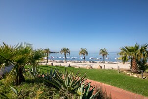 Praia particular, espreguiçadeiras, guarda-sóis, toalhas de praia 