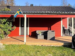 Um edifício vermelho com uma bandeira, varanda e móveis de exterior.