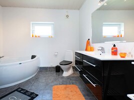 Uma casa de banho moderna com banheira, sanita e lavatório.
