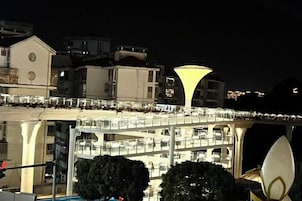 Um edifício com vários níveis, varandas e uma estrutura em forma de ponte conectando os andares.
