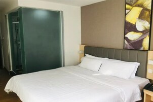 Quarto de hotel com cama, guarda-roupa e um quadro na parede.