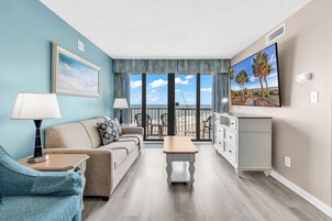 Condo com design assinado, 1 cama King e sofá-cama, sacada, vista para o oceano | Sala de estar | Smart TV 55 polegadas com canais digitais, TV