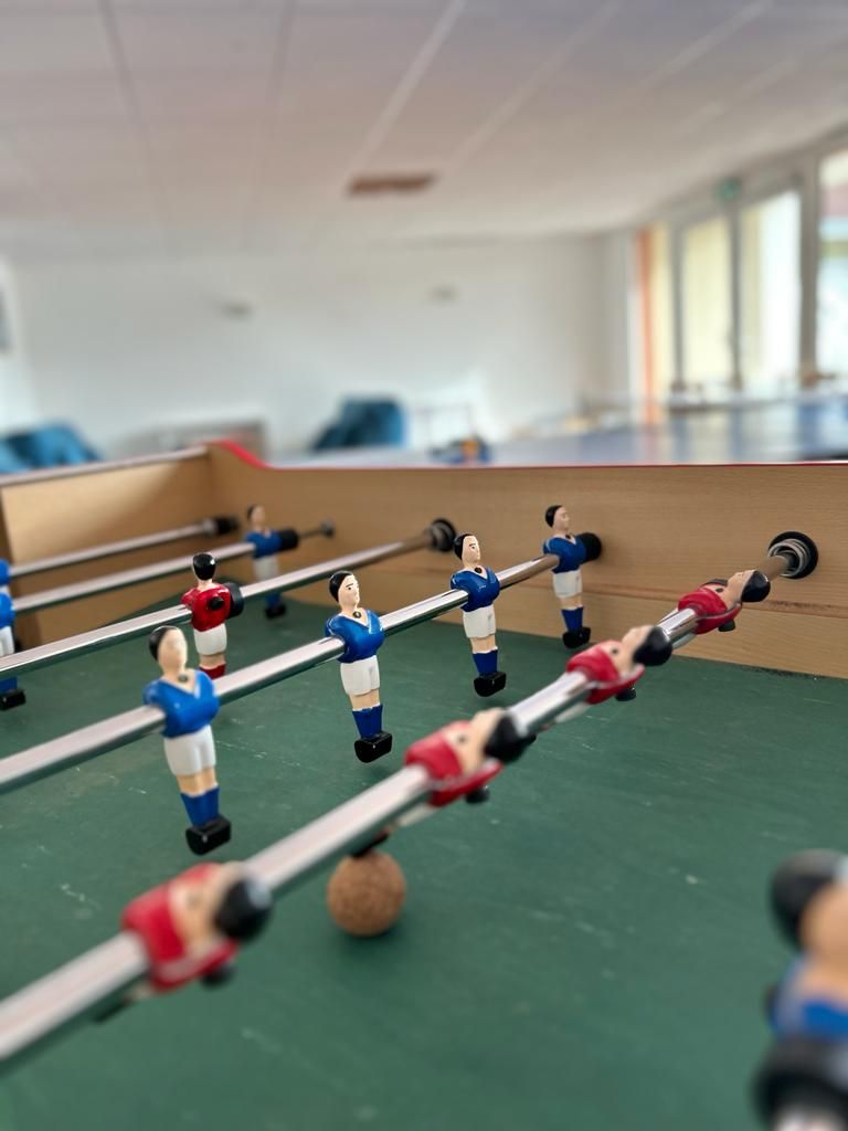 Uma mesa de futebol de mesa com jogadores de uniforme azul e vermelho.
