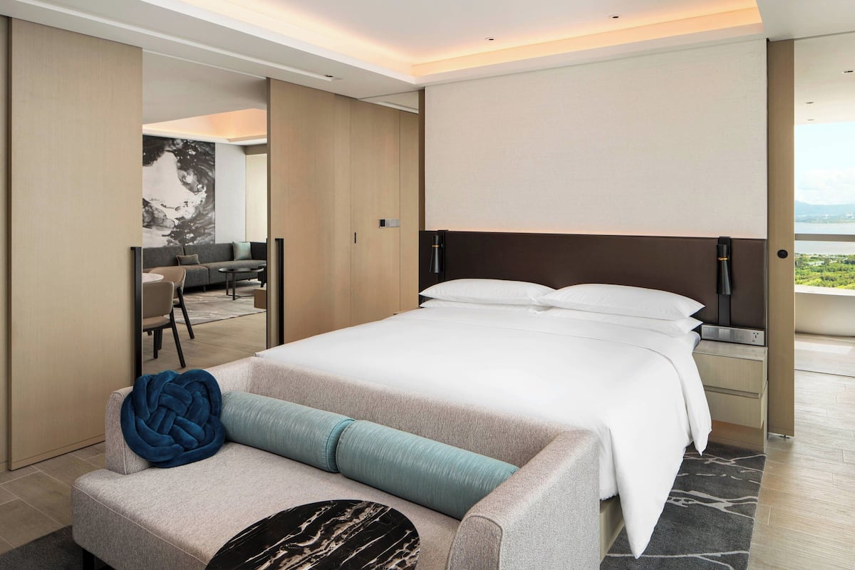 Quarto de hotel moderno com uma cama grande, um sofá e uma área de trabalho.