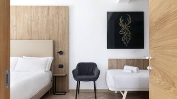 Quarto de hotel moderno com cabeceira de madeira, uma cadeira preta, cama branca e uma obra de arte abstrata em preto e branco na parede.