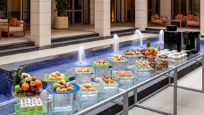 Buffet com diversos alimentos e uma fonte.