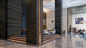 Um lobby moderno com palco, área de estar e balcão de recepção.