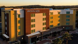 Um hotel com vários andares e design moderno, com uma placa chamativa da 'Springhill Suites by Marriott'.