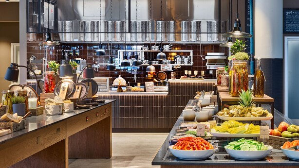 Cozinha moderna com ilha central, diversos alimentos e utensílios de cozinha.
