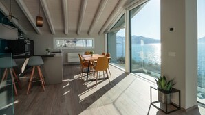 Cozinha moderna com área de jantar, janelas amplas e vista para o mar.