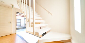 Uma escada moderna com design minimalista, que leva a uma porta com painel de vidro.