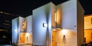 Um edifício moderno com três portas, cada uma com uma pequena luz acima.