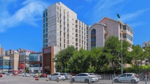 Um edifício moderno com vários andares, grandes janelas e fachadas de vidro e concreto.